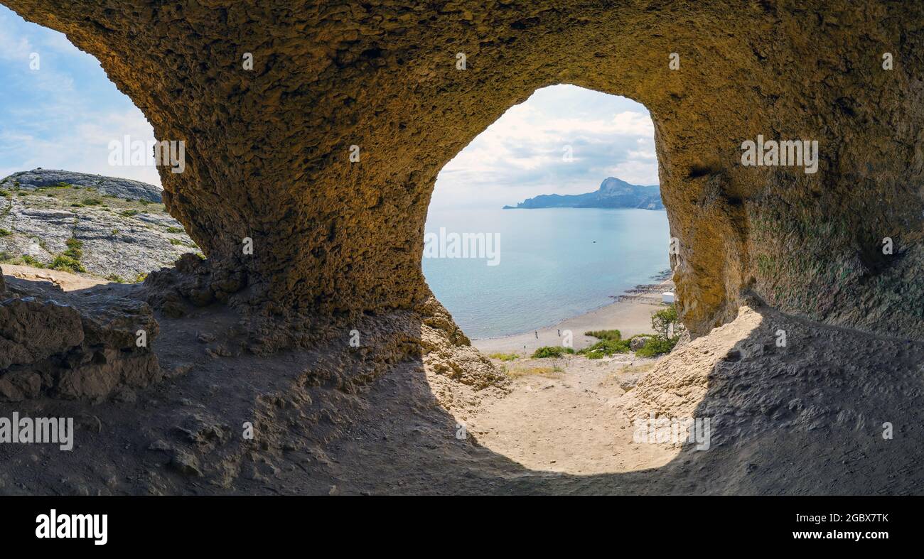 Sea view from a small cave on the slope of the coastal mountain Aeolian ...