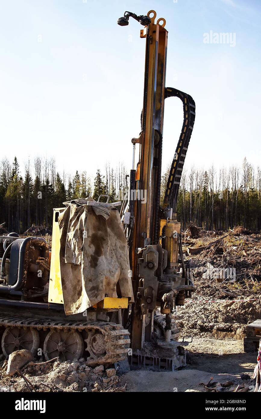 Mini-drilling rig on crawler track on site of sawn forest where large ...