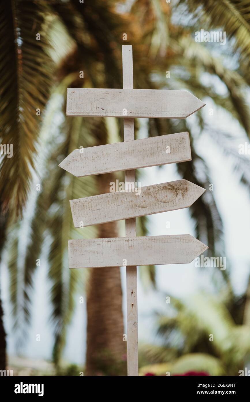 Close-up of a wooden sign in a park with several arrows indicating ...