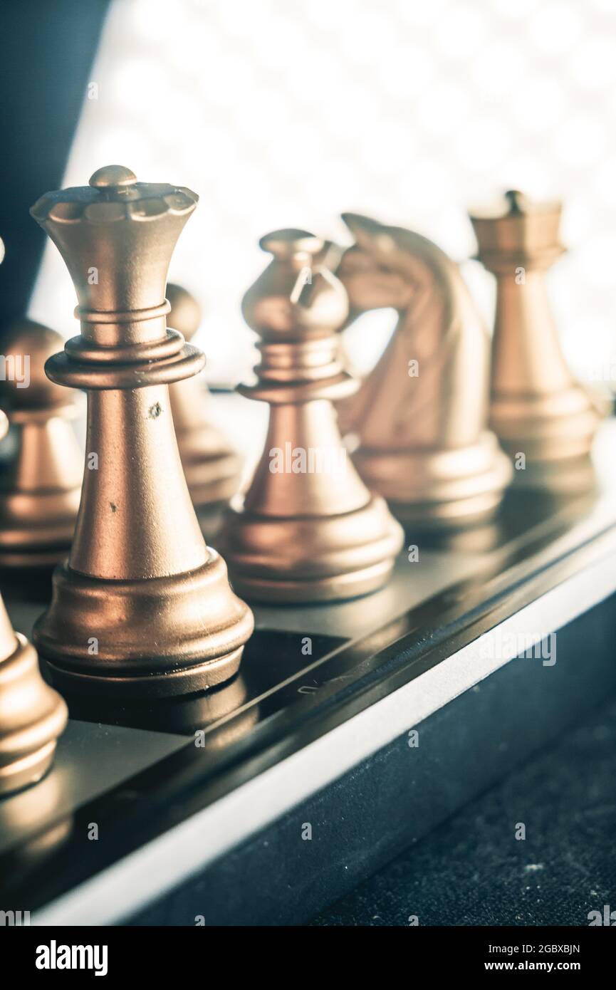 Vertical shot of golden chess pieces on a chessboard Stock Photo - Alamy