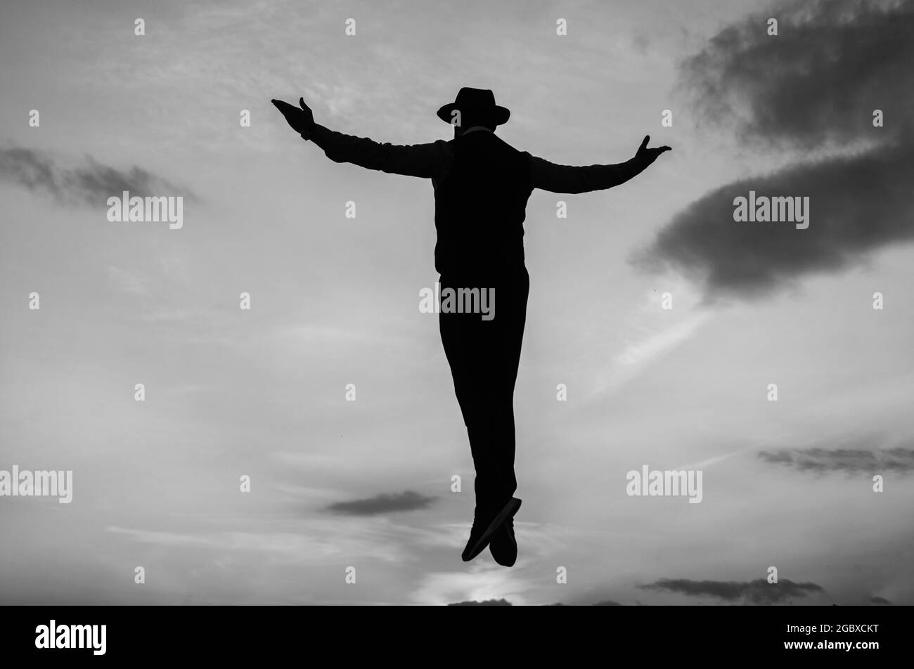 silhouette of man float in sunrise sky with raised hands, freedom Stock ...