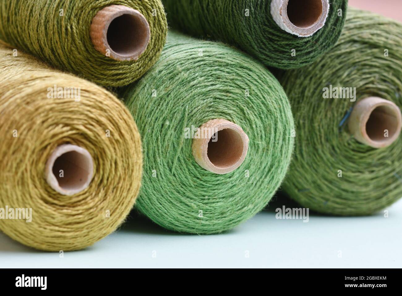 Photo of threads in different shades of green on bright background ...