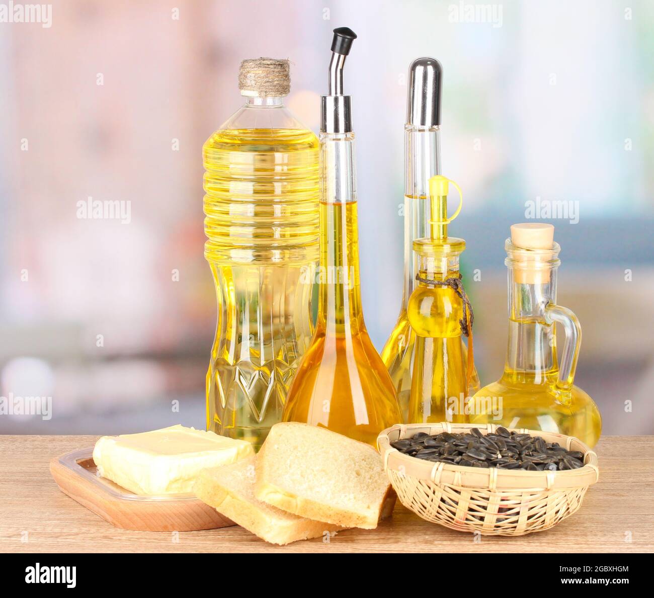 Different types of oil with sunflower seeds on table in kitchen Stock ...