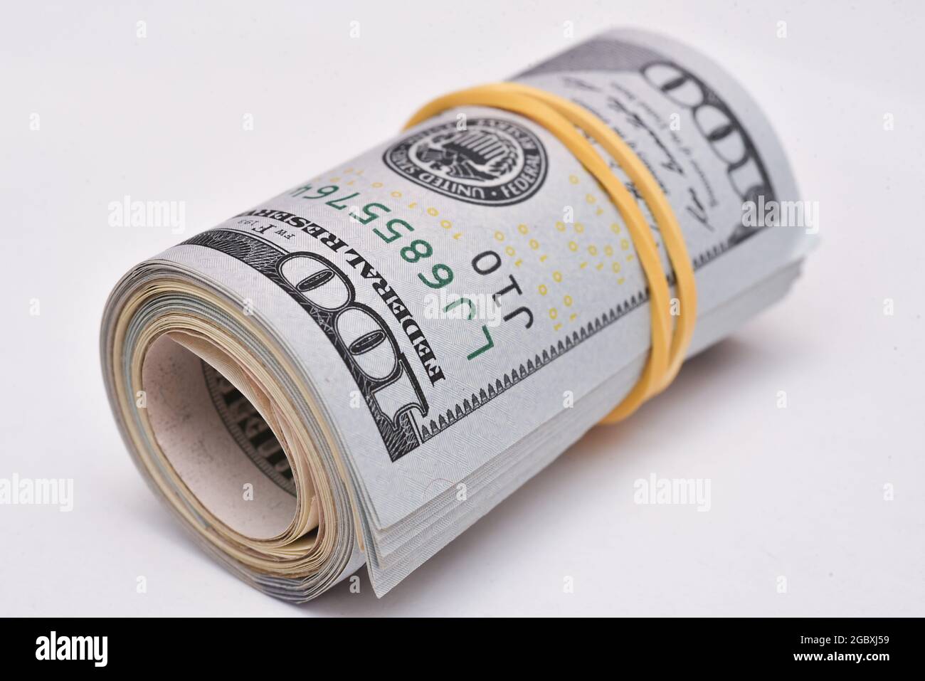 In this photo illustration, rolled American dollar bills with a rubber ...