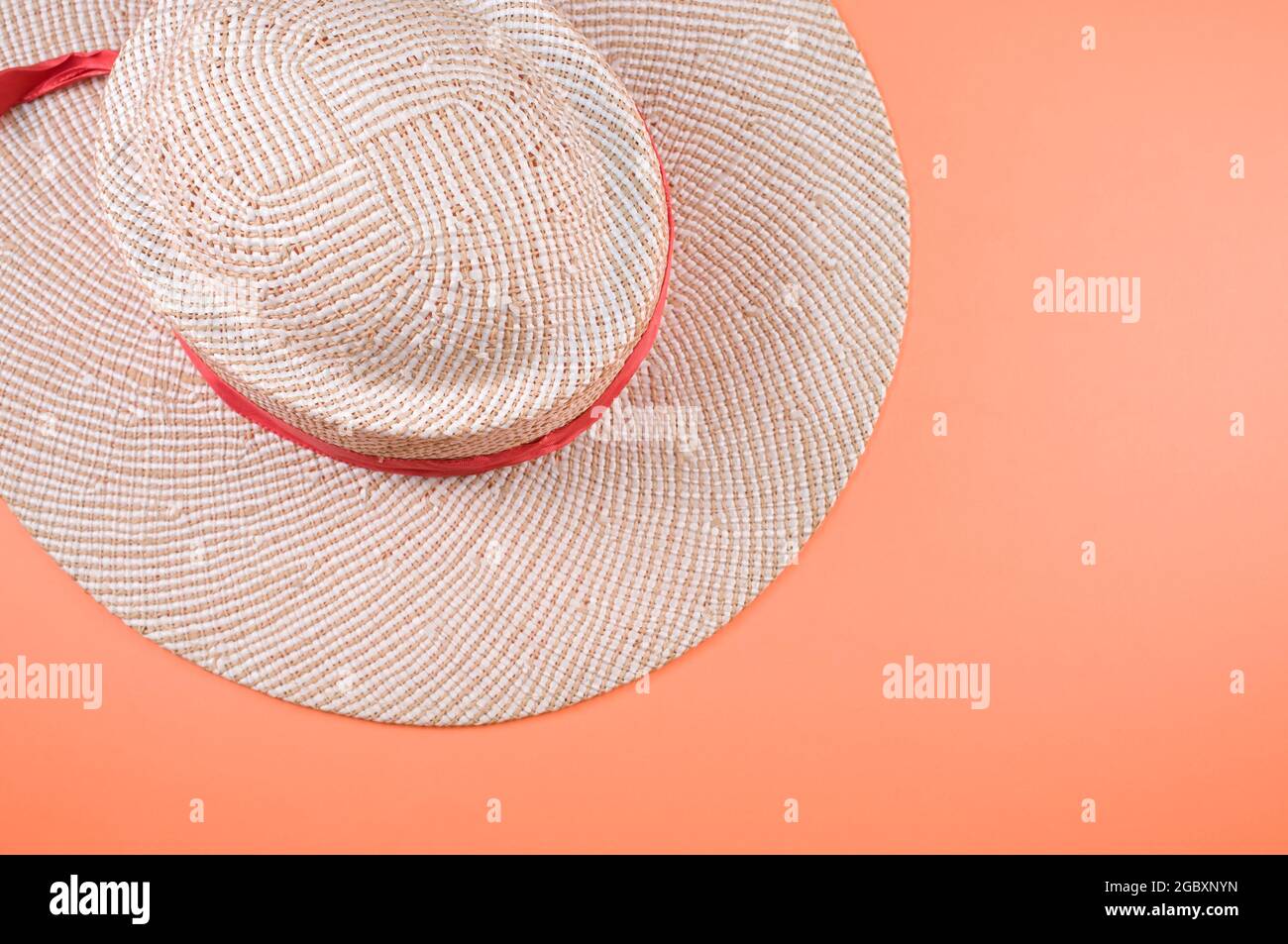 Top view of a straw hat with red ribbon isolated on an orange ...