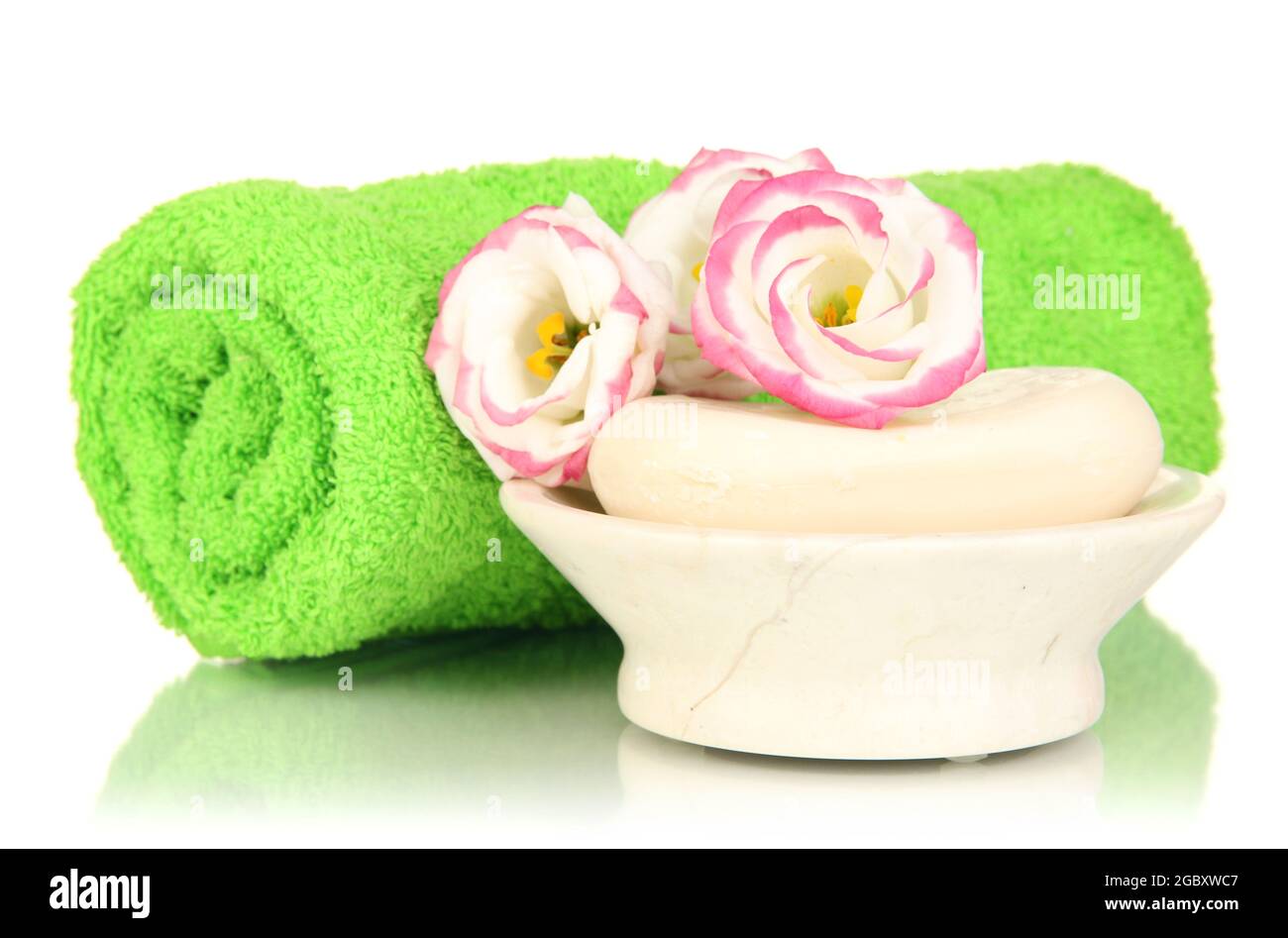 Rolled green towel, soap bar and beautiful flower isolated on white ...