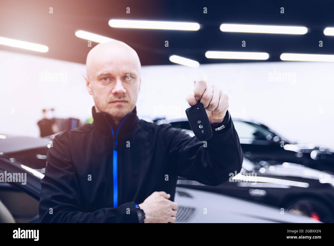 Car mechanic in service holding car keys Stock Photo - Alamy