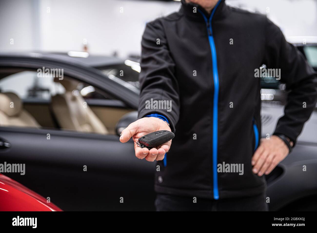 Car mechanic in service holding car keys Stock Photo - Alamy