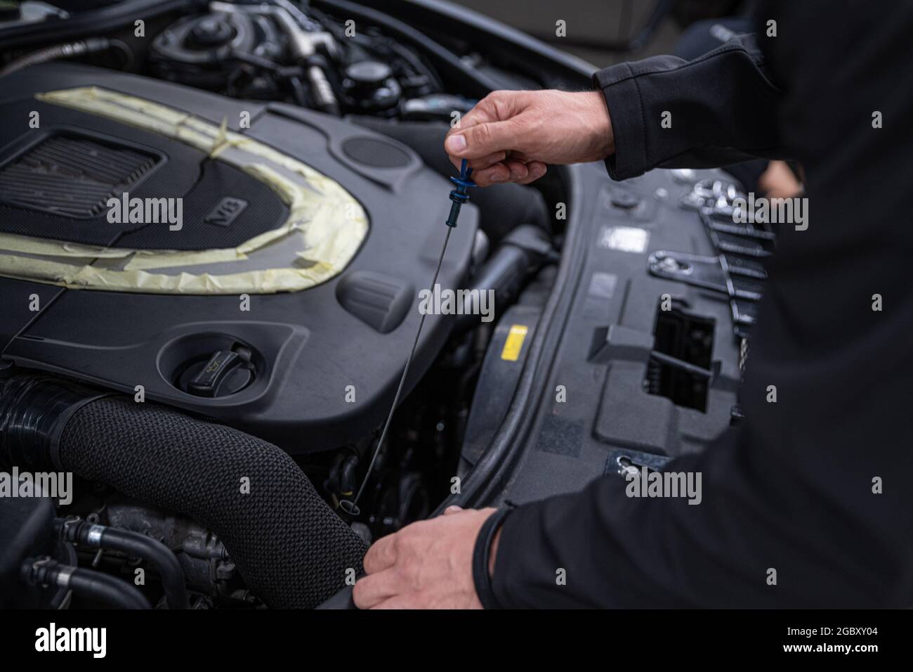 Mechanic checking oil level in car service Stock Photo - Alamy