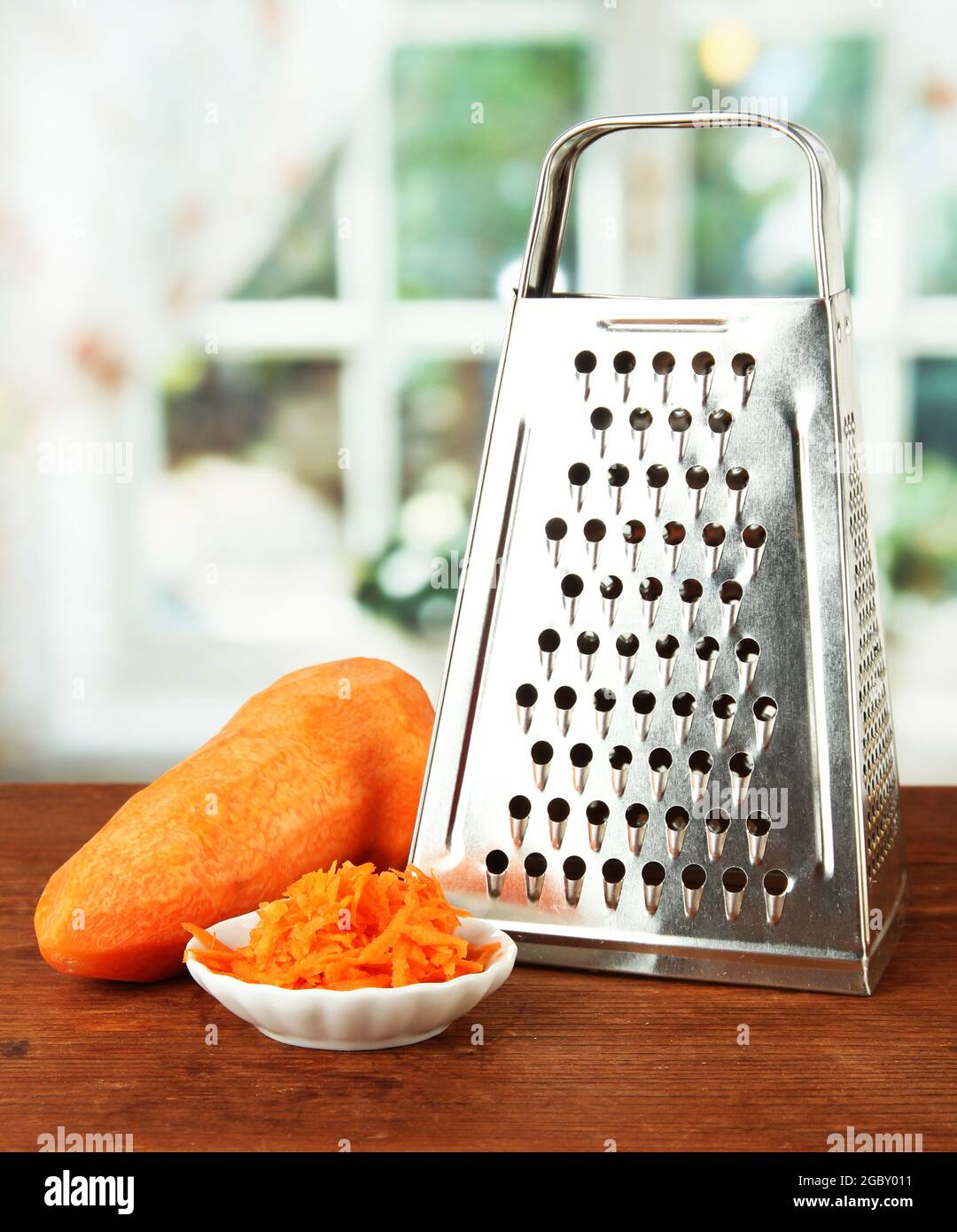 Metal grater and carrot, on bright background Stock Photo - Alamy