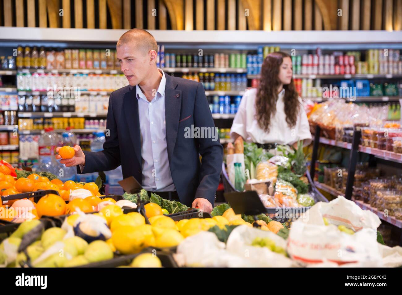 Female shopper picks ripe oranges on grocery store Stock Photo - Alamy