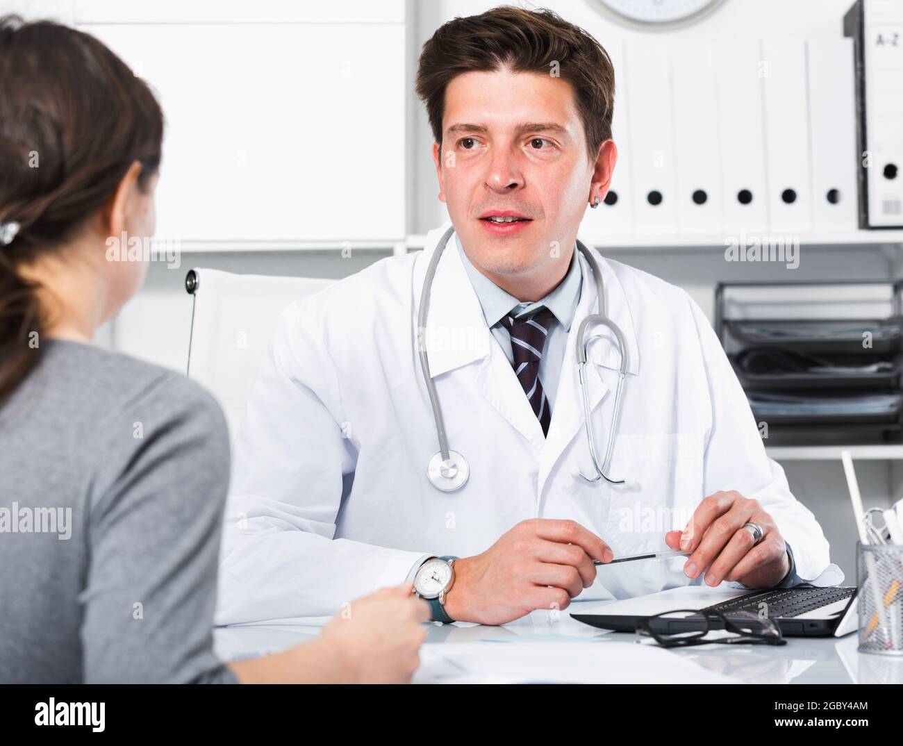 Doctor speaking with client in the medical center Stock Photo - Alamy