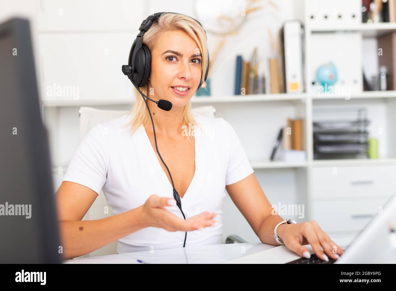 Female operator talking with customer using headset at company office ...