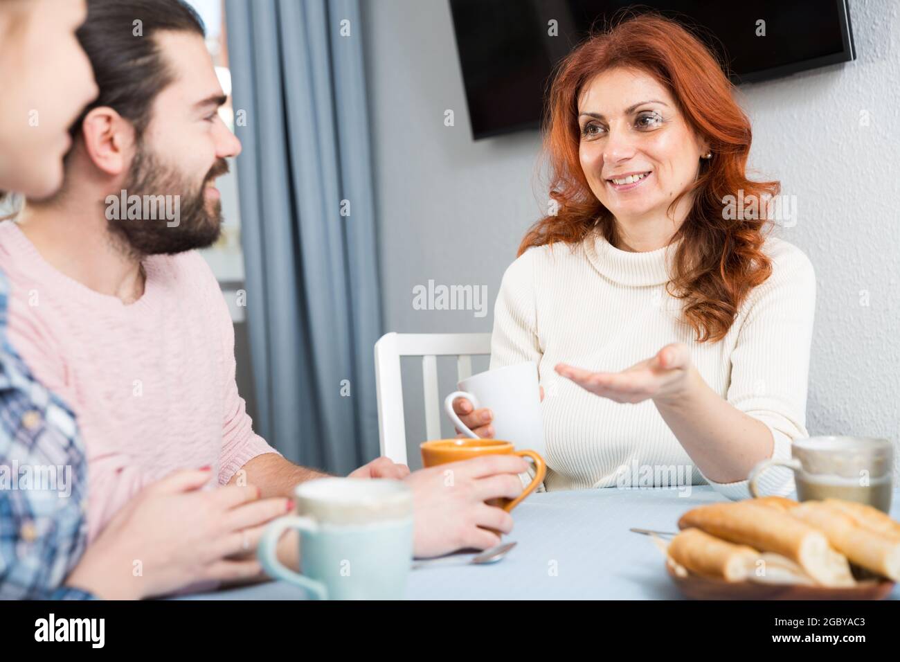 Mature woman with daughter talking at table with cup of tea Stock Photo ...