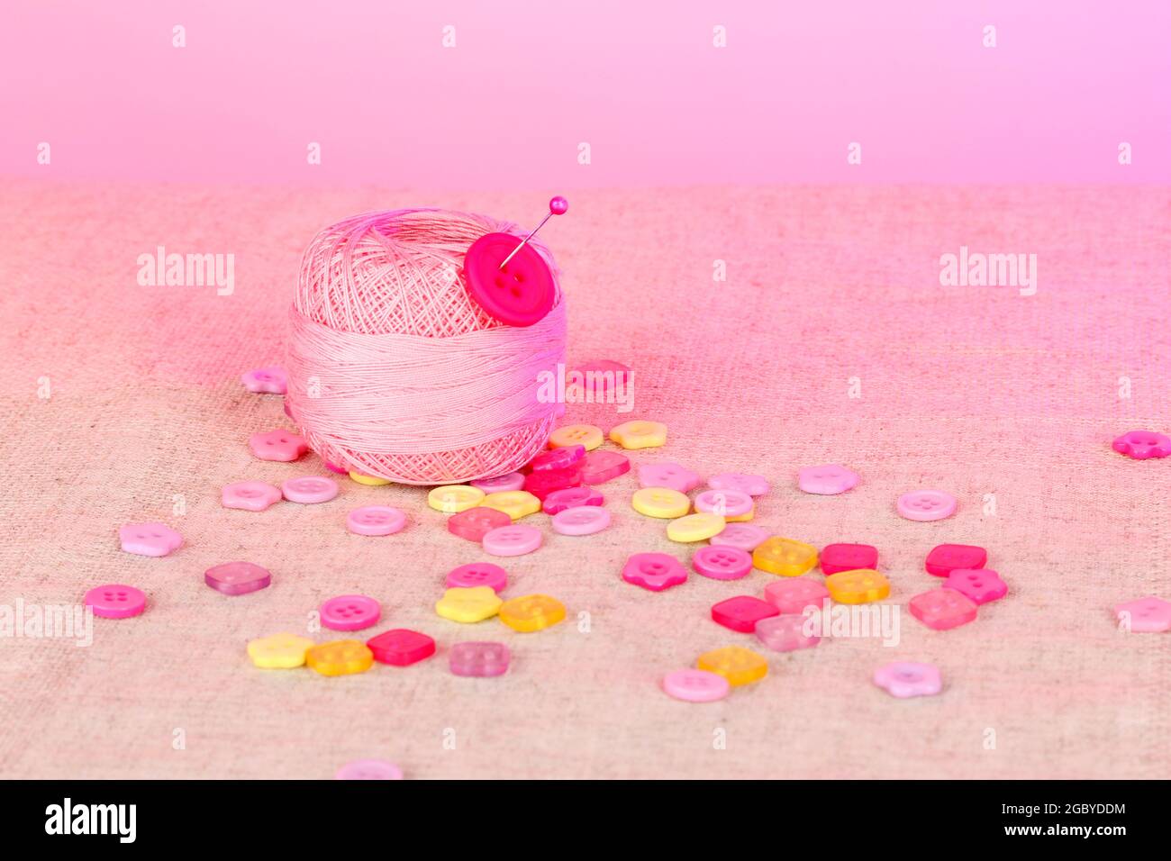Beautiful buttons and a ball of yarn on a pink background Stock Photo ...