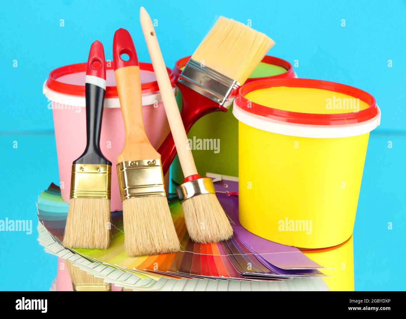 Set for painting: paint pots, brushes, palette of colors on blue ...