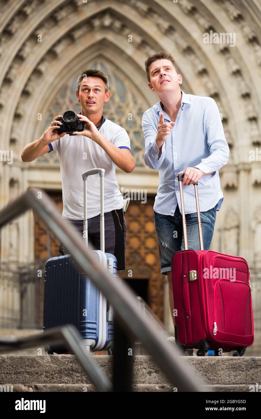 positive man tourist with baggage taking photo Stock Photo - Alamy