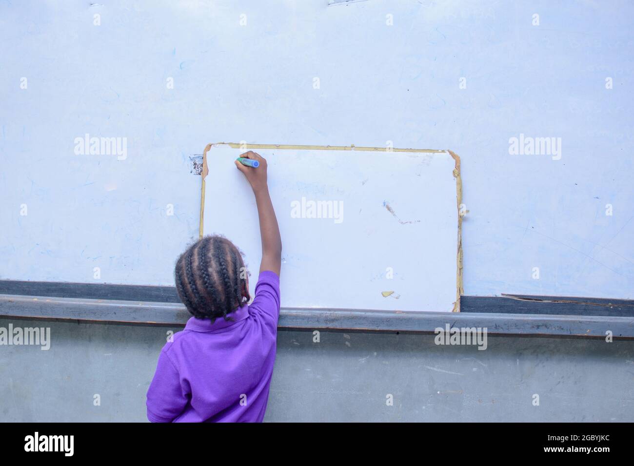 African girl child, pupil or student standing in a classroom and ...