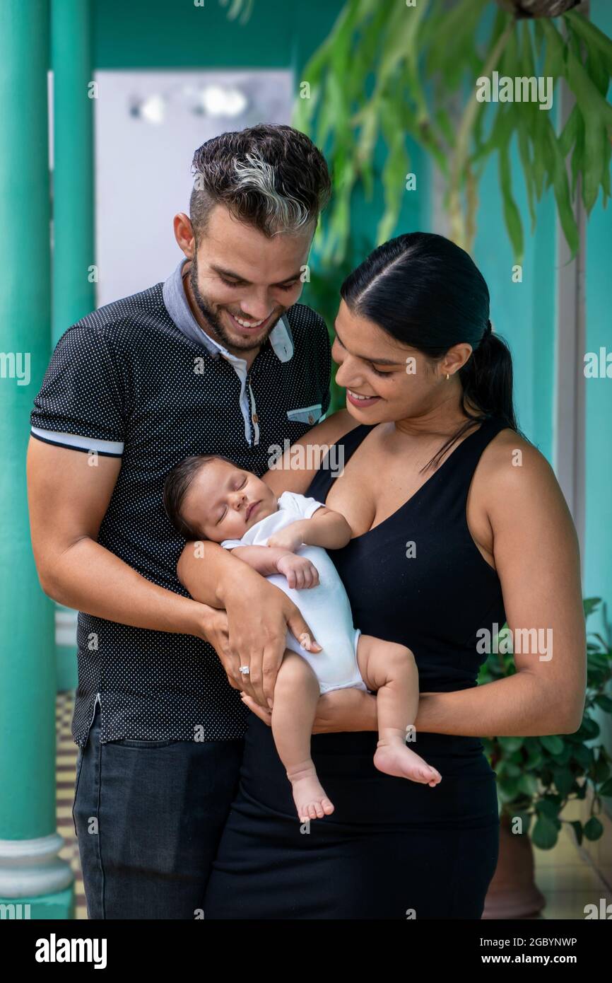 Photo of a baby in the arms of a woman and a man Stock Photo - Alamy