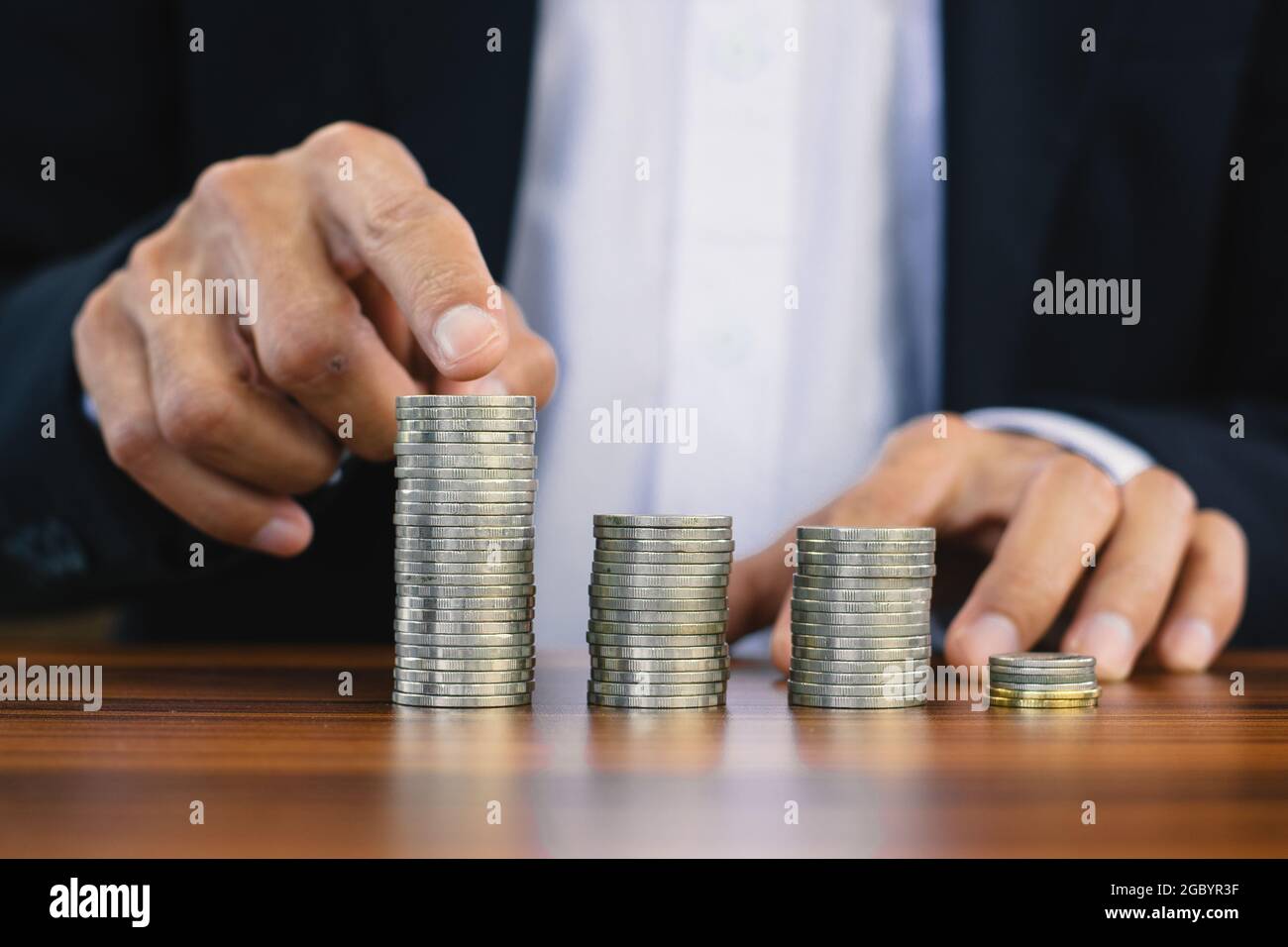 Hand counting coins stack on wooden table, Cons stack saving money or ...