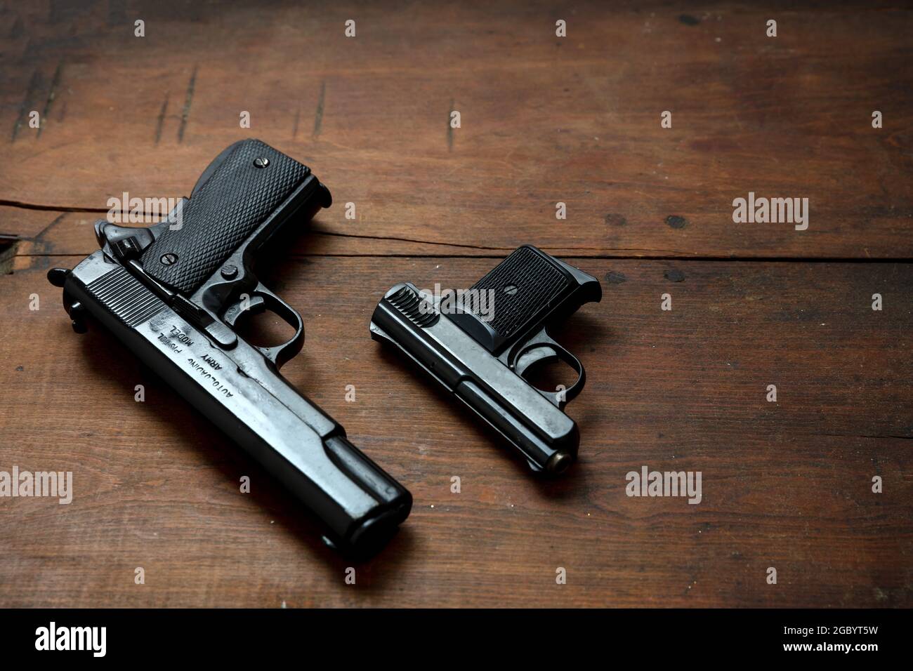 Guns on wooden background. Two black metal pistol weapons, automatic ...