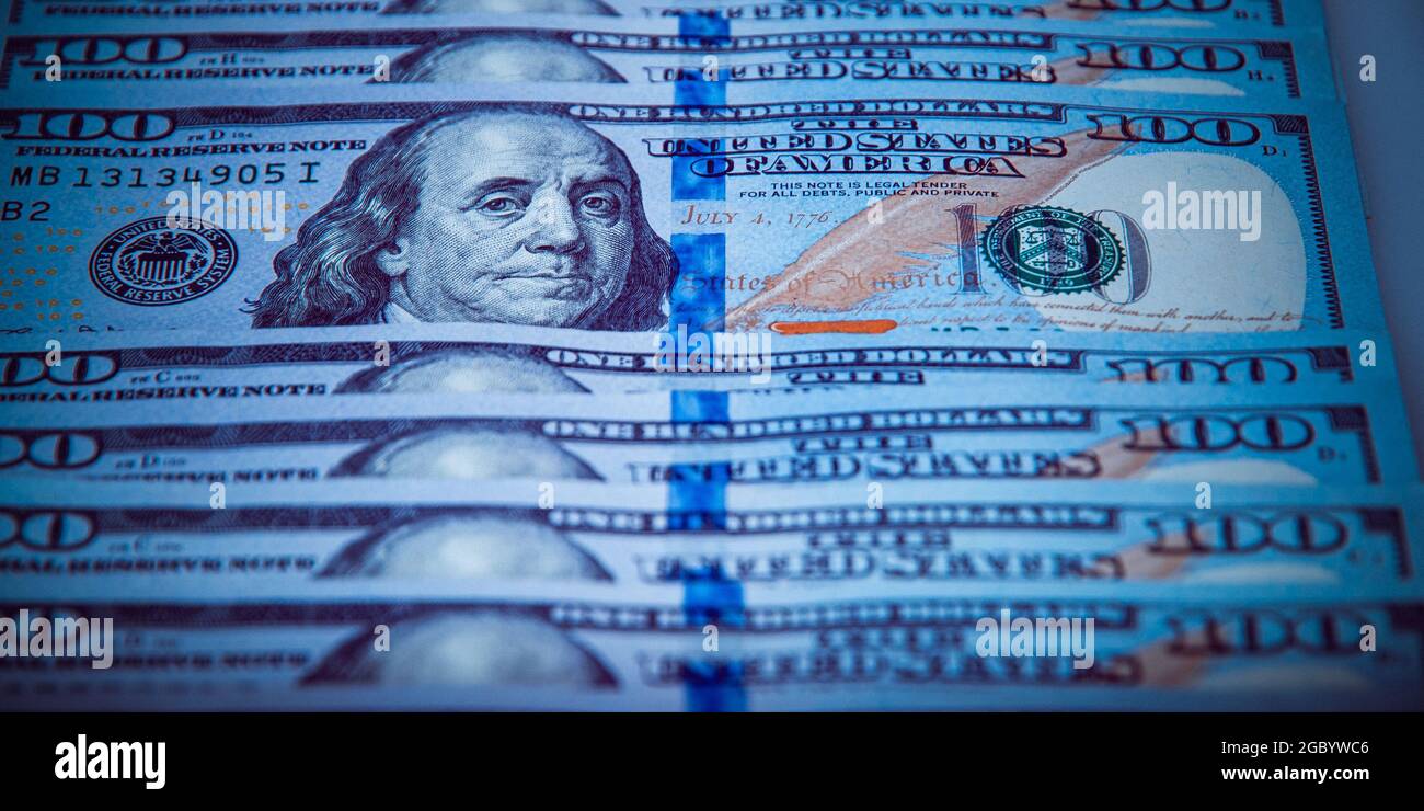 One hundred dollar bills are in a row, one stands out, selective focus ...