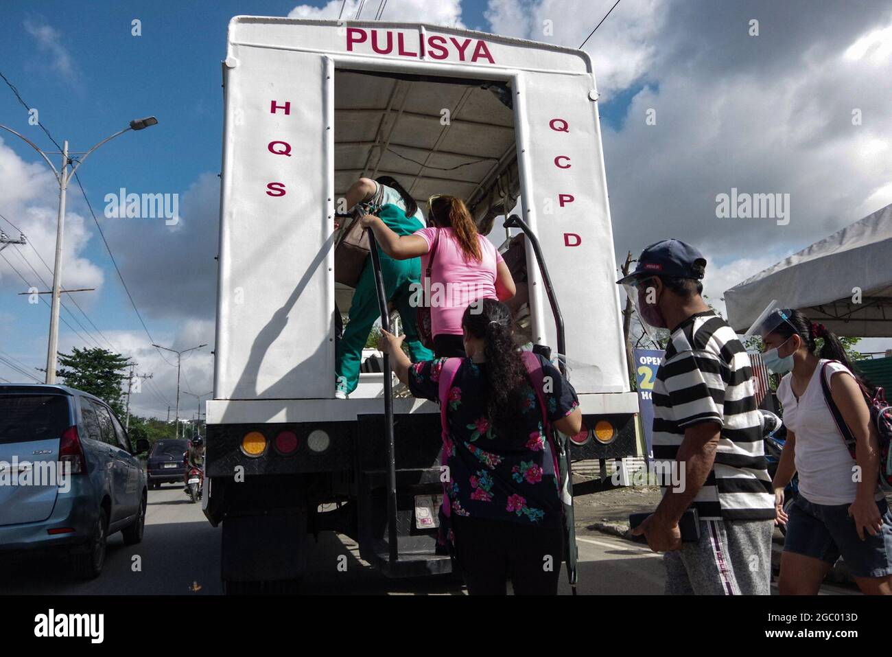 Stranded commuters take free rides provided by QCPD at a border between ...