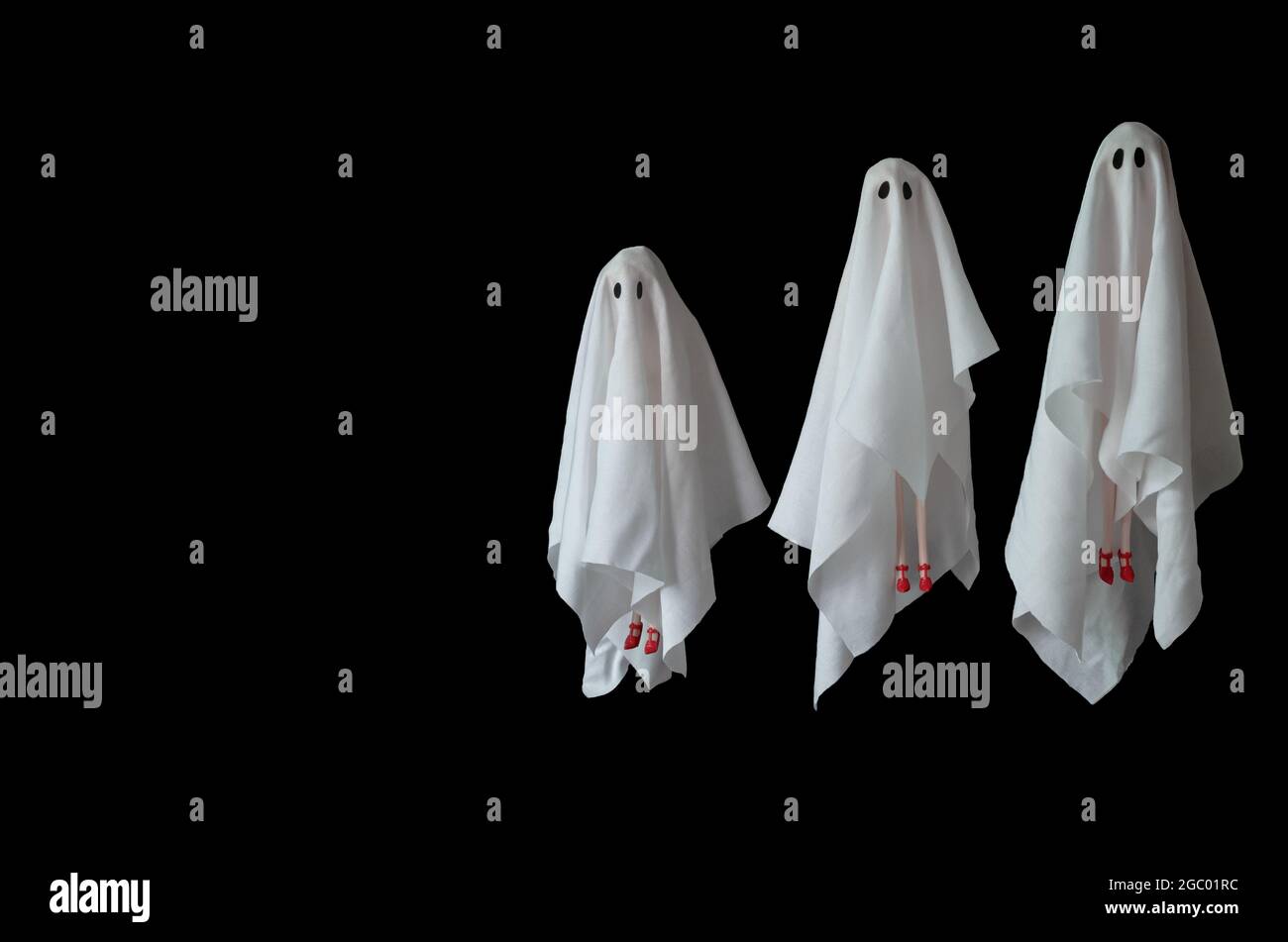 A group of female ghost white sheet costume flying in the air with ...