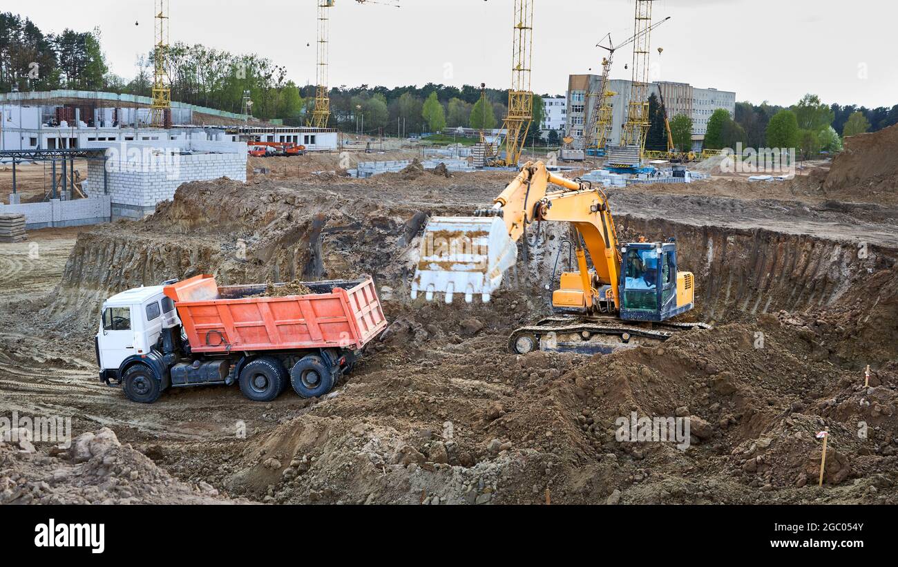 Crawler excavator in process of loading sand and soil to multi-ton ...