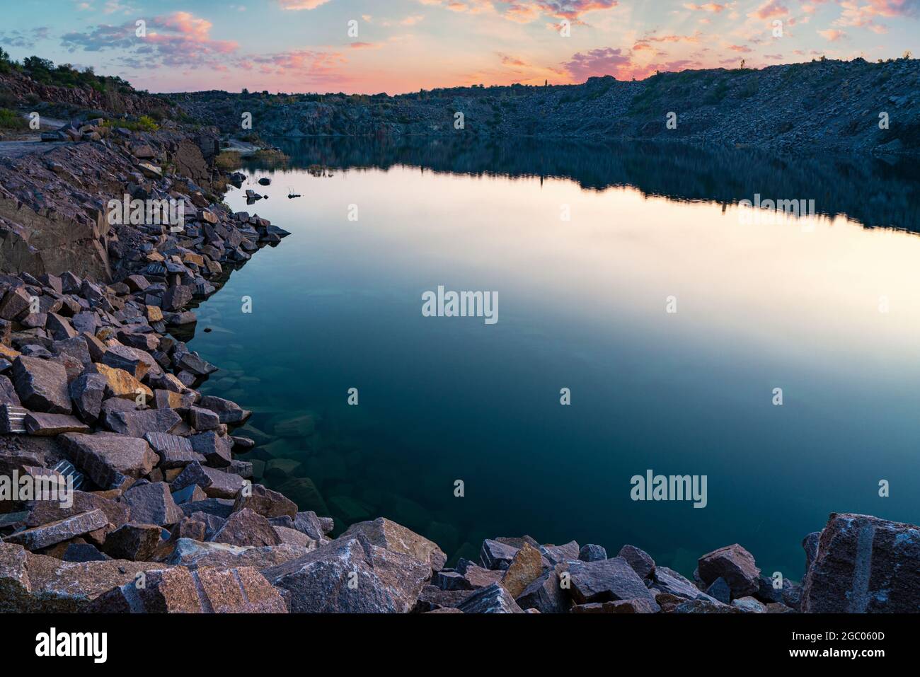 Small lake surrounded by stone waste from mine work Stock Photo - Alamy