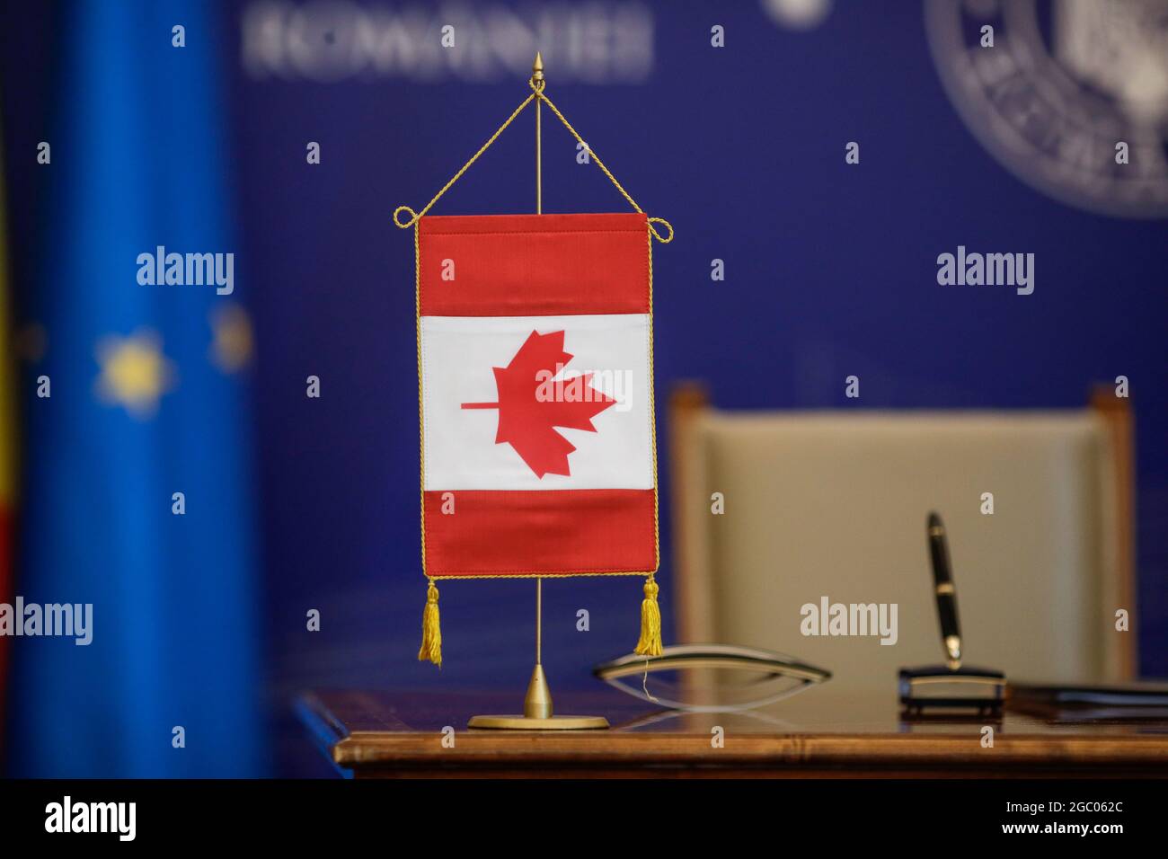 Canadian flag on a wooden desk before the signing of a document by a ...