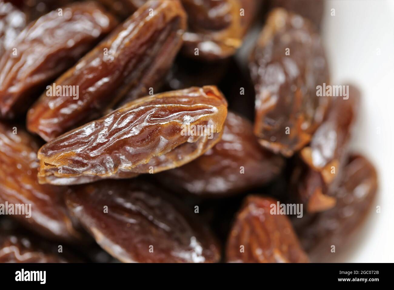 Dry dates close-up in a white plate . dates pile. Sweet fruit healthy ...