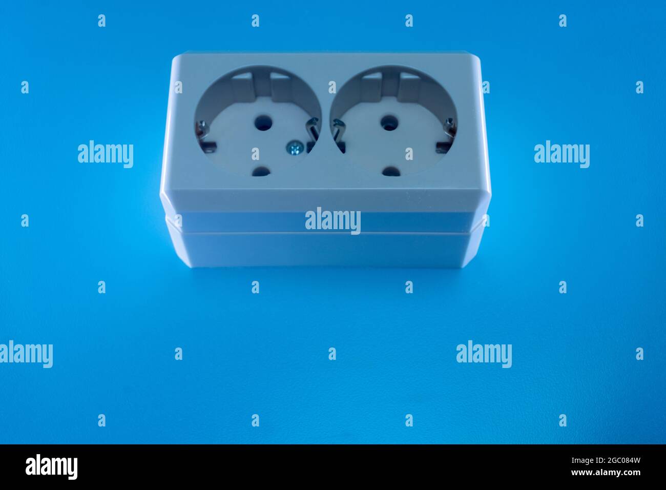 Electric double socket on a blue background Stock Photo - Alamy