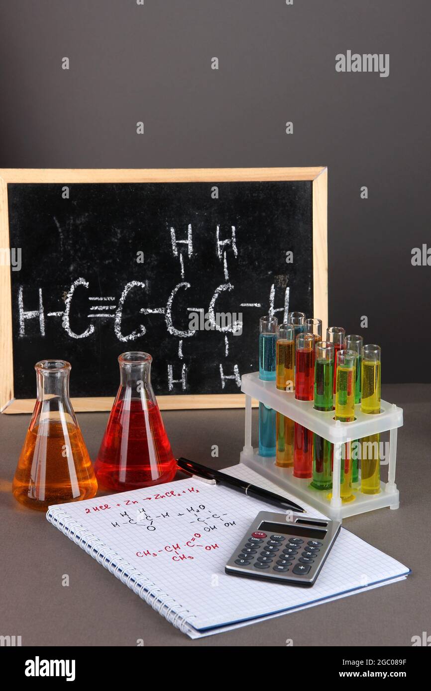 Test tubes with colorful liquids and formulas on grey background Stock ...