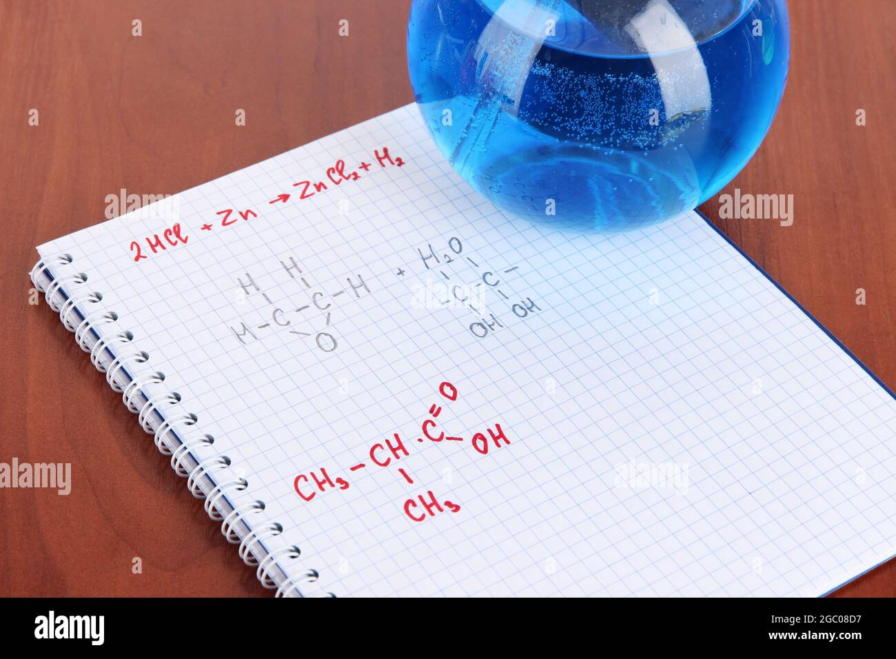 Test tube with colorful liquid and formulas on table Stock Photo - Alamy