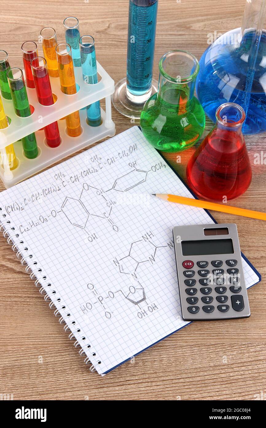 Test tubes with colorful liquids and formulas on table Stock Photo - Alamy