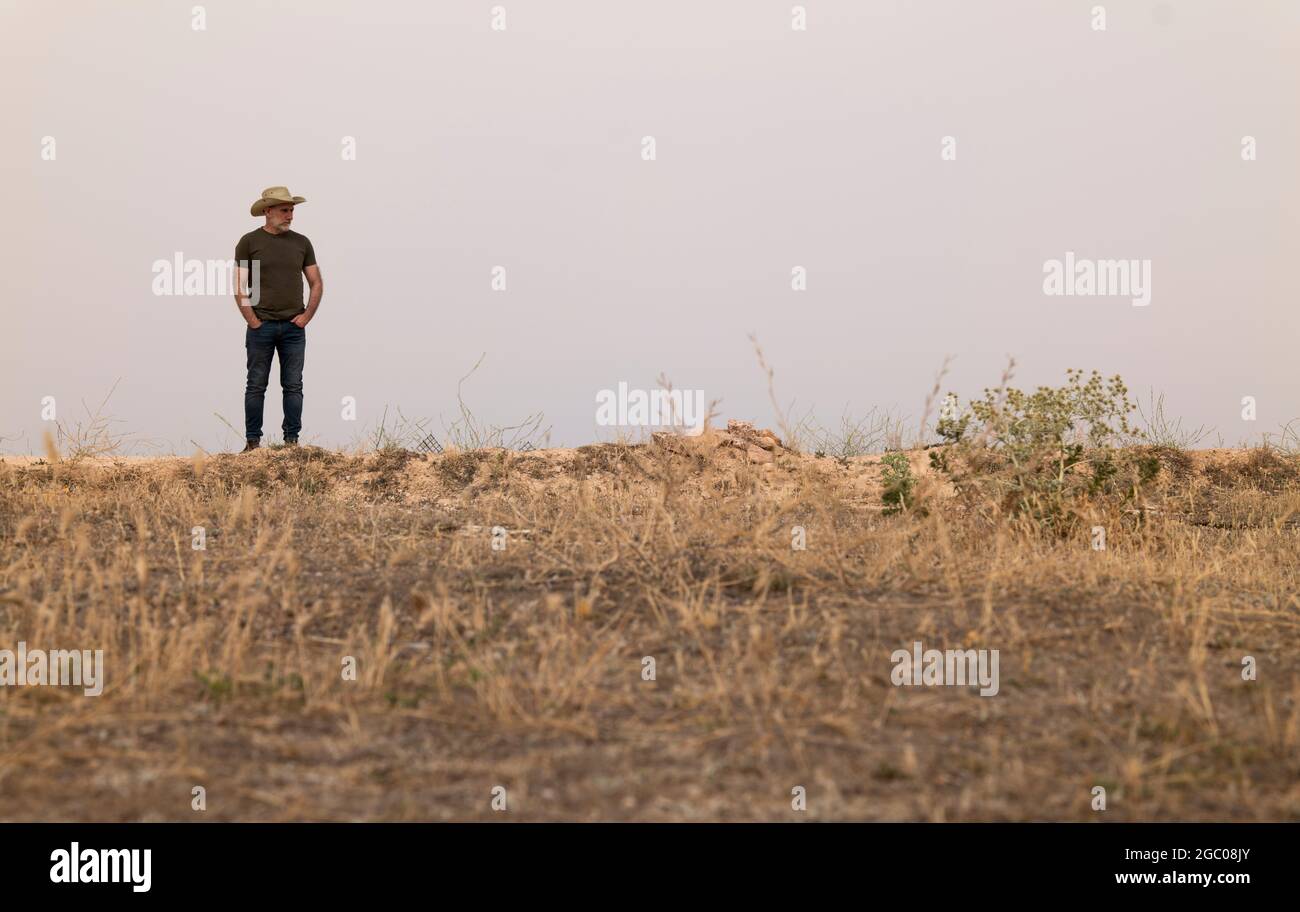 A man wearing a cowboy hat in the countryside Stock Photo - Alamy