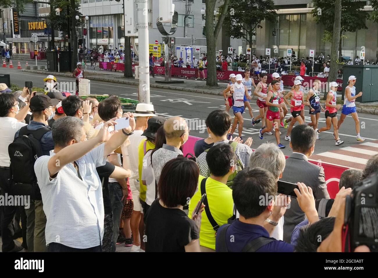 People watch the Tokyo Olympic men's 20-kilometer race walk on Aug. 5 ...