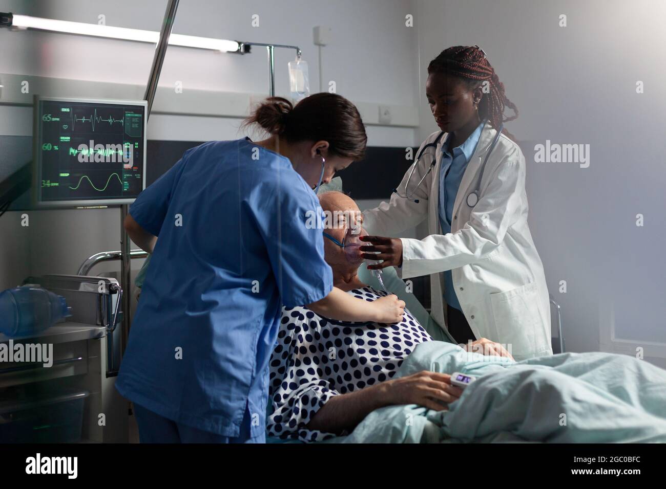 African doctor helping senior patient breath using repiratory ...