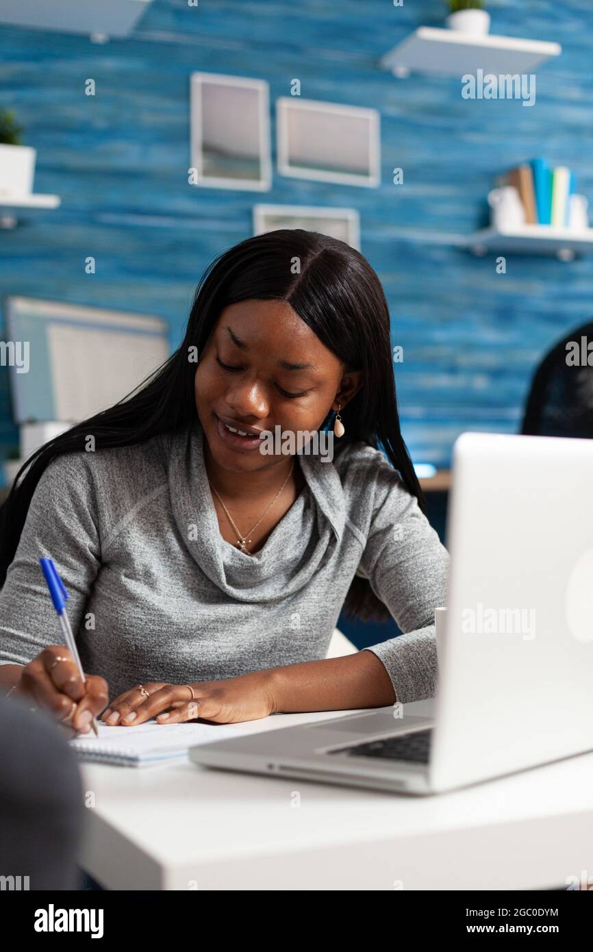 Afro american student writing math homework on notebook during high ...