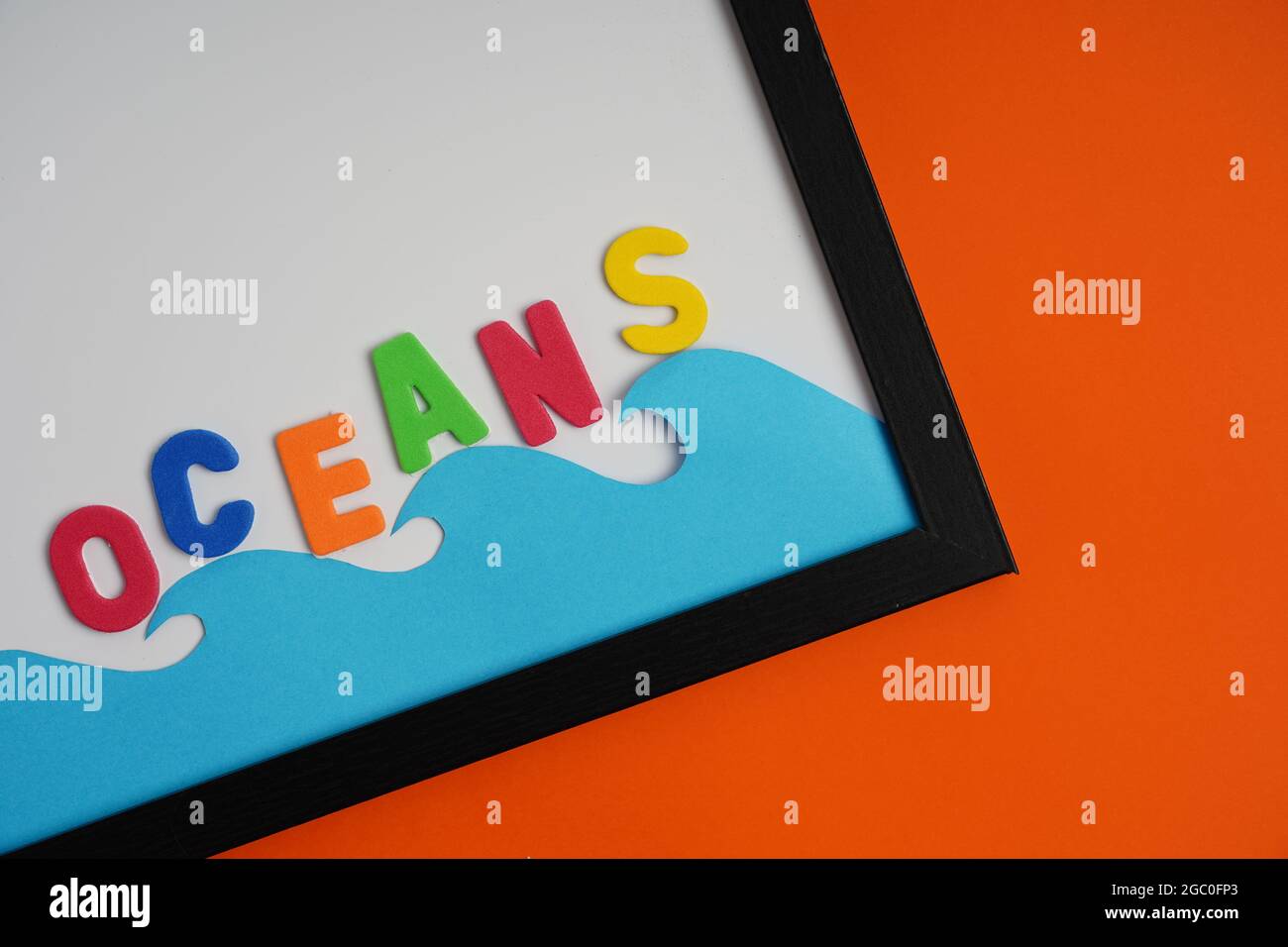 Word oceans written in colored alphabets on a frame with an orange ...
