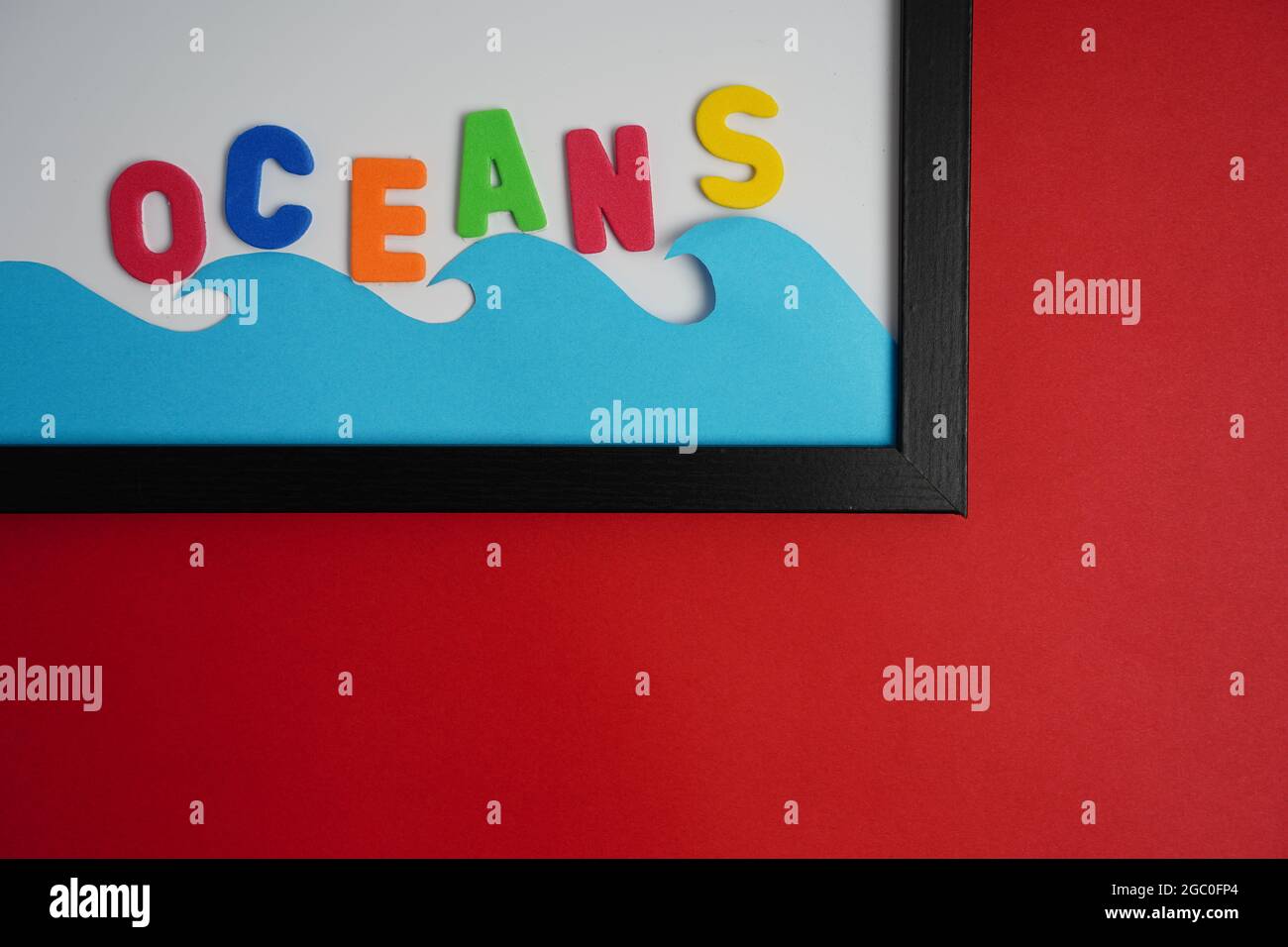 Word oceans written in colored alphabets on a frame with a red ...