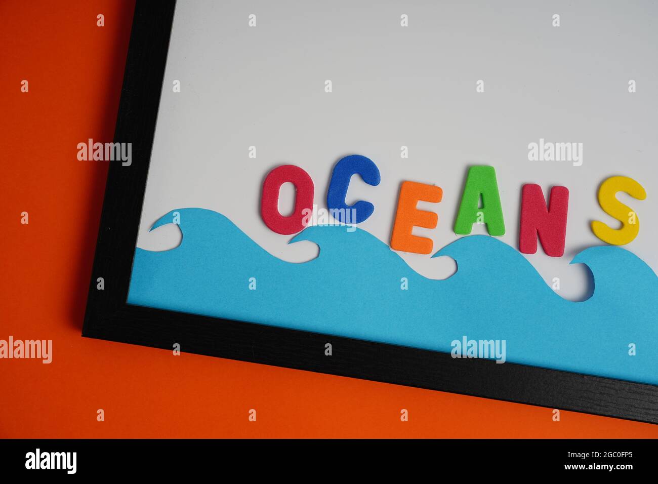 Word ocean written in colored alphabets on a frame with an orange ...