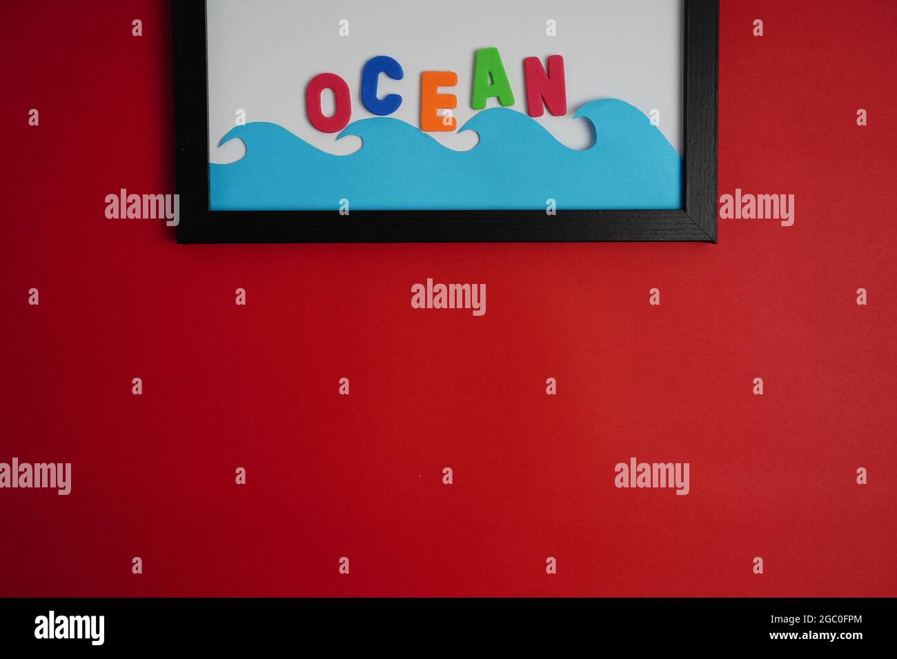 Word ocean written in colored alphabets on a frame with a red ...