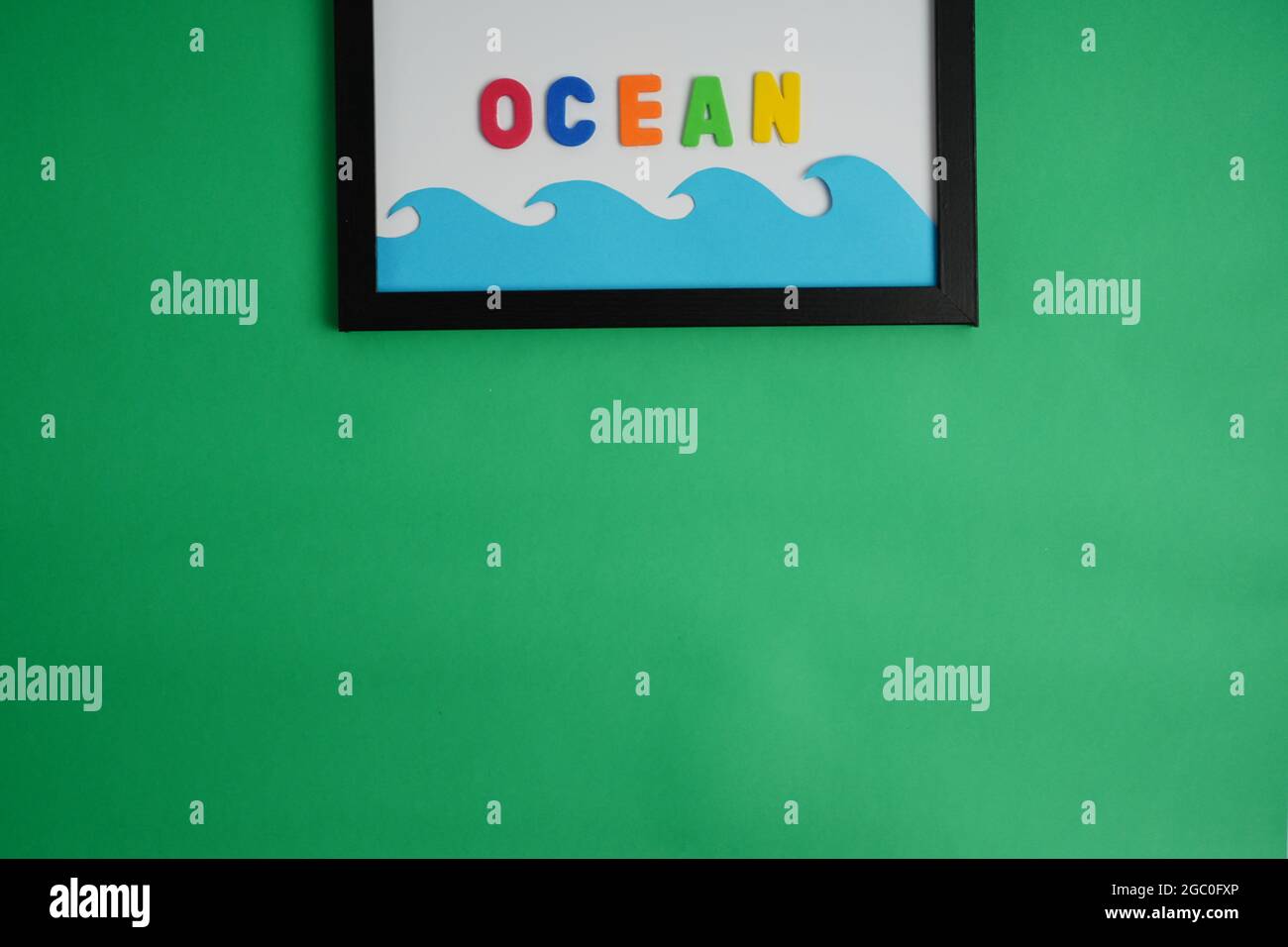 Word ocean written in colored alphabets on a frame with a green ...