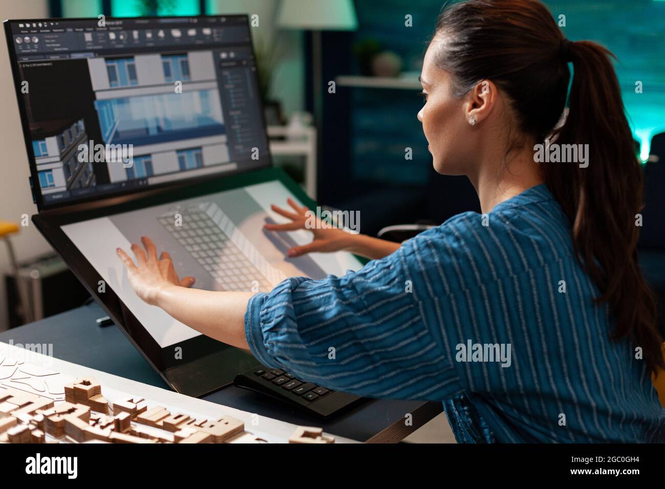 Professional woman architect working on building plan using modern ...