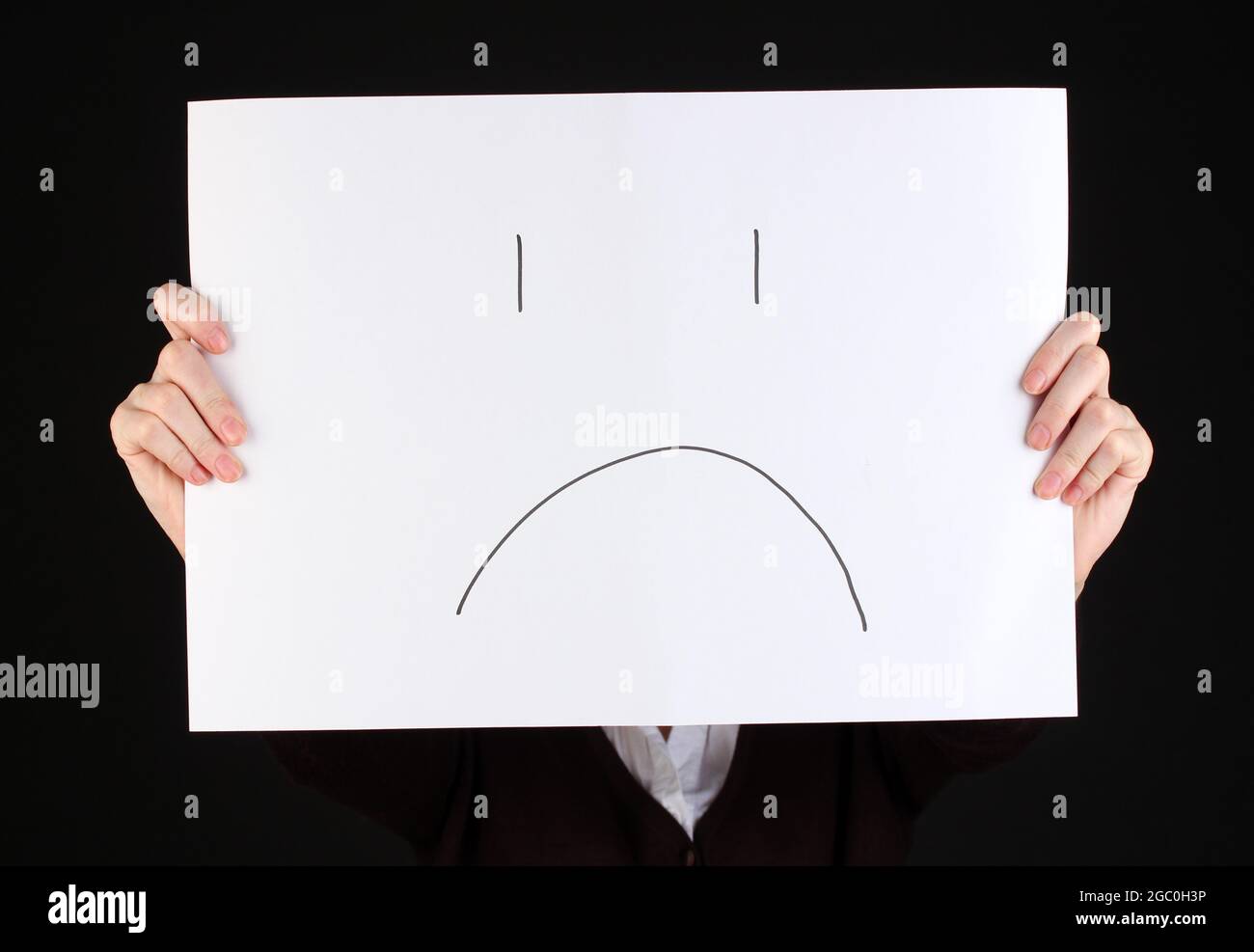 Woman holding paper with sad emoticon, isolated on black Stock Photo ...
