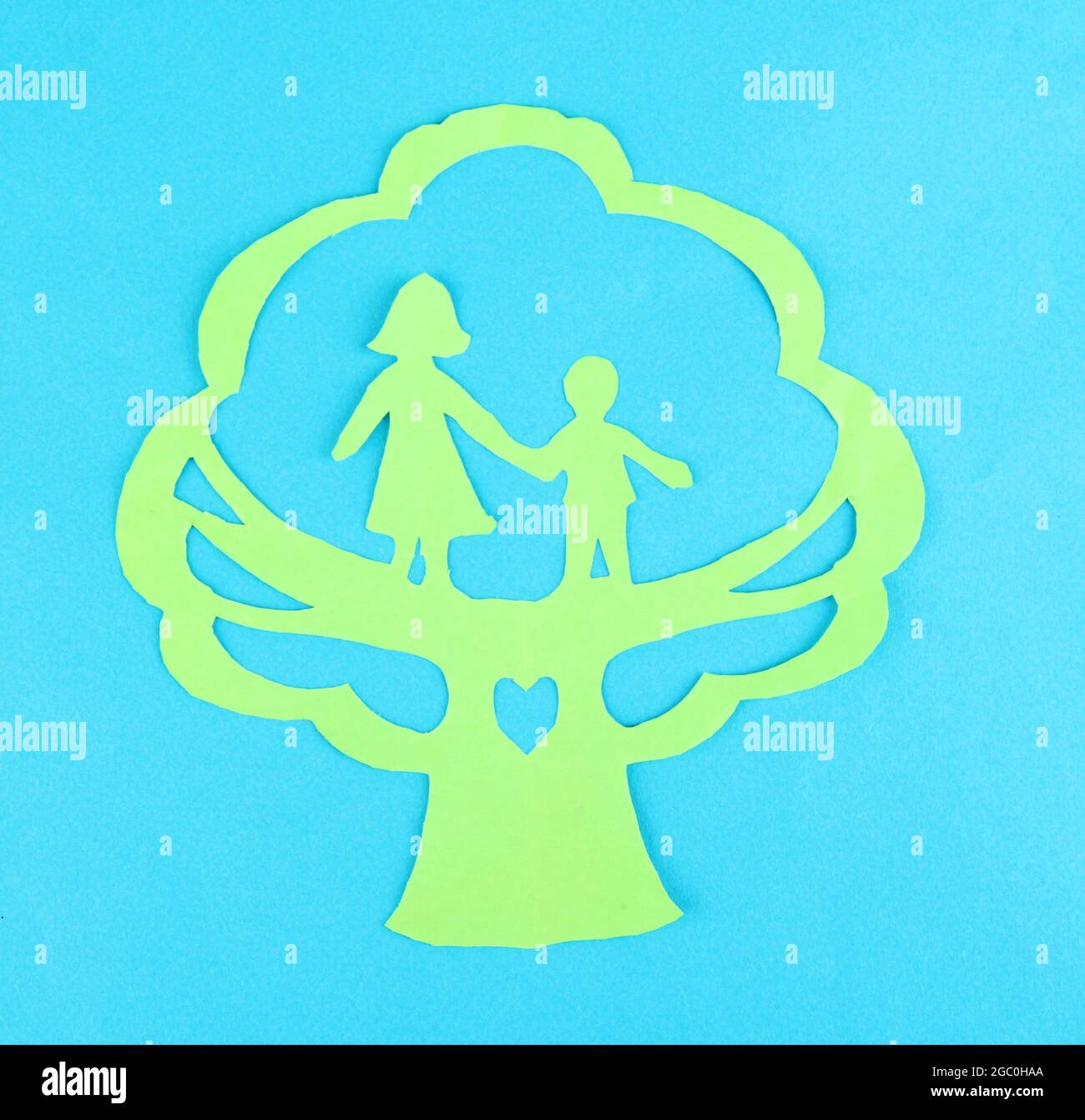 Green cut out paper tree with people inside, on color background Stock ...