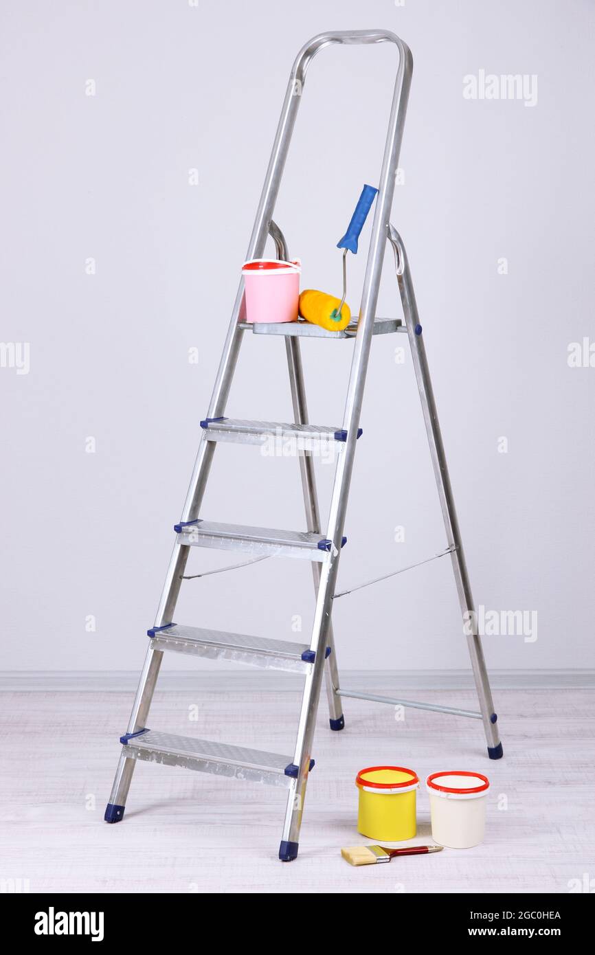 Metal ladder and paint in room Stock Photo - Alamy