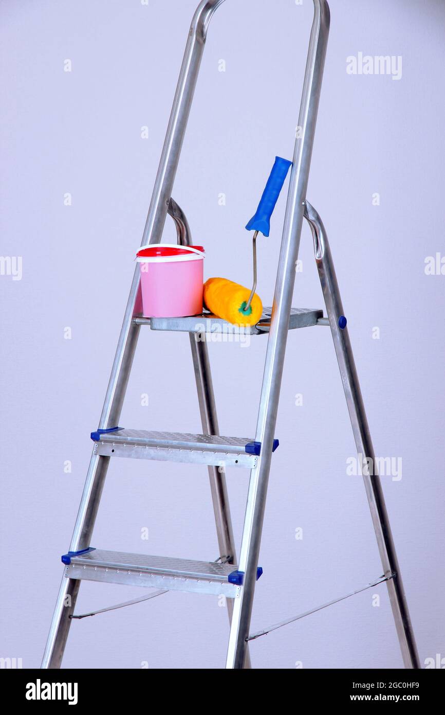 Metal ladder and paint in room Stock Photo - Alamy